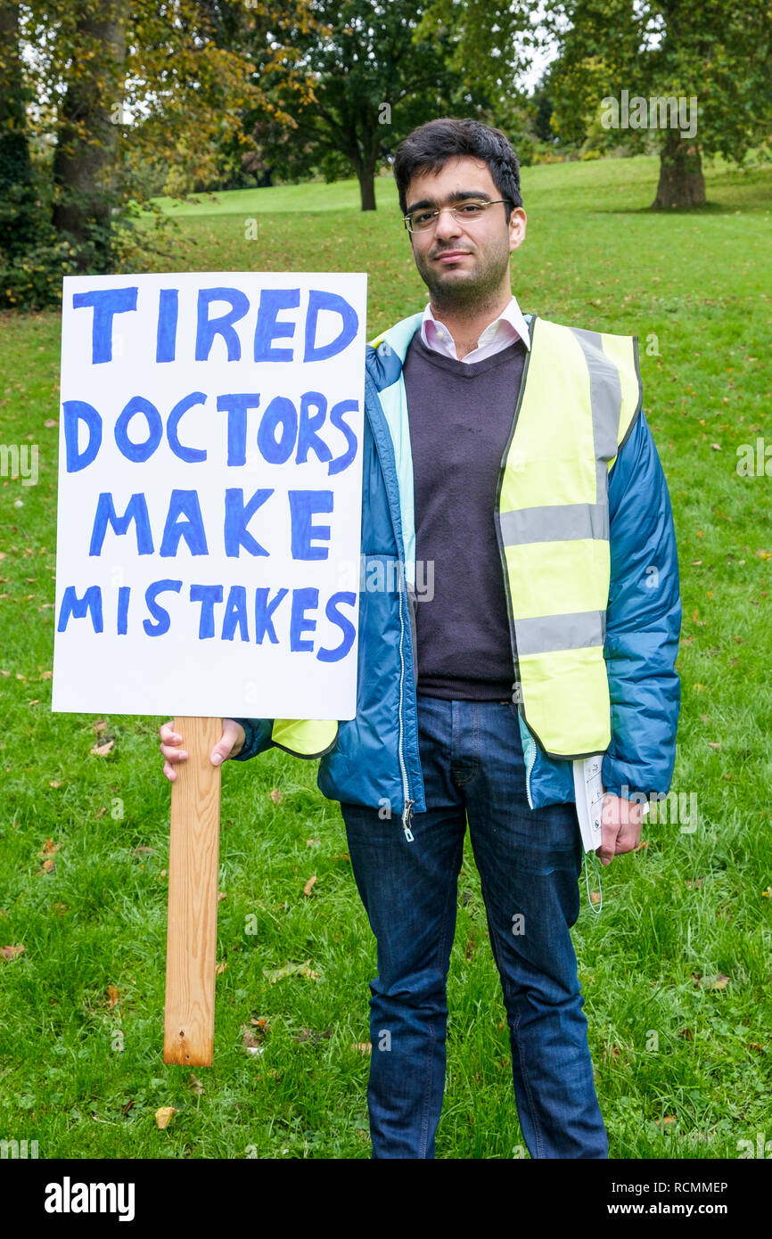 NHS staff and members of the public are pictured carrying placards and ...
