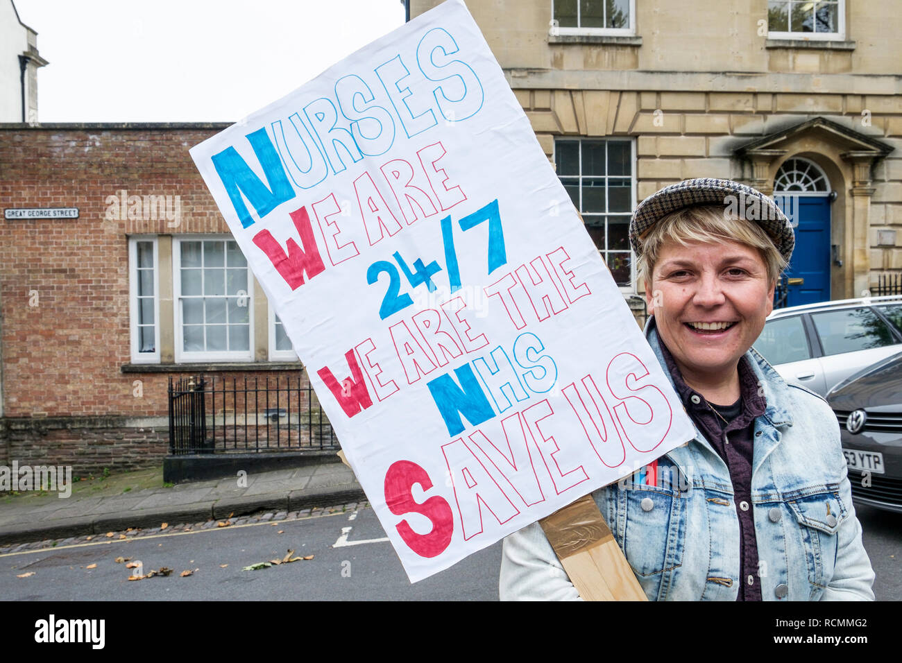 NHS staff and members of the public are pictured carrying placards and ...