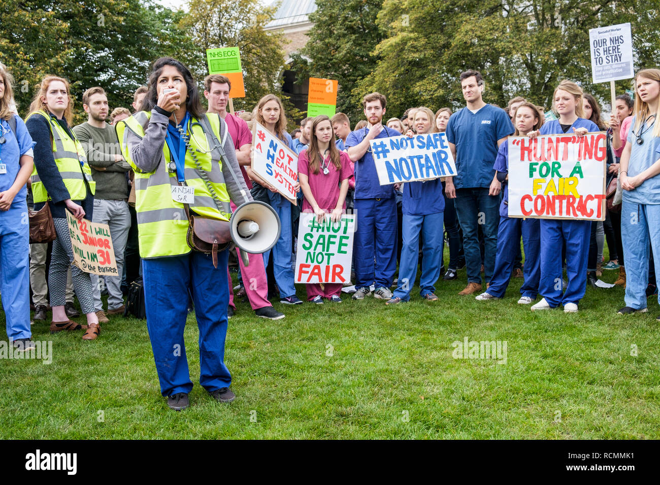 NHS staff and members of the public are pictured carrying placards and ...