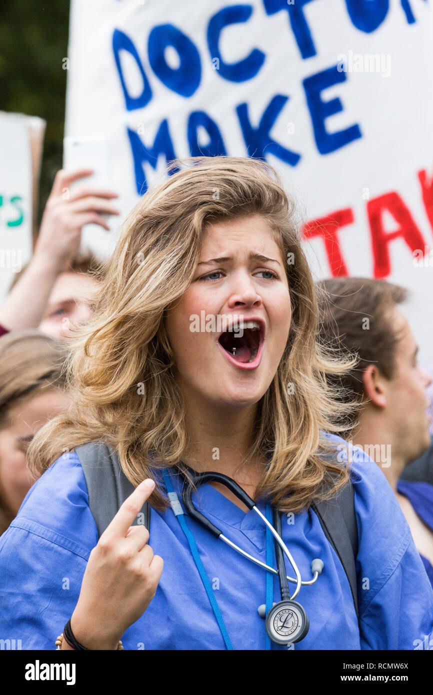 NHS staff and members of the public are pictured carrying placards and ...