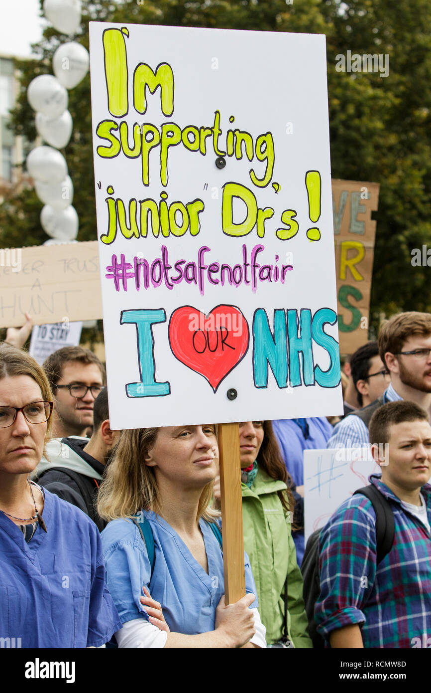 NHS staff and members of the public are pictured carrying placards and ...