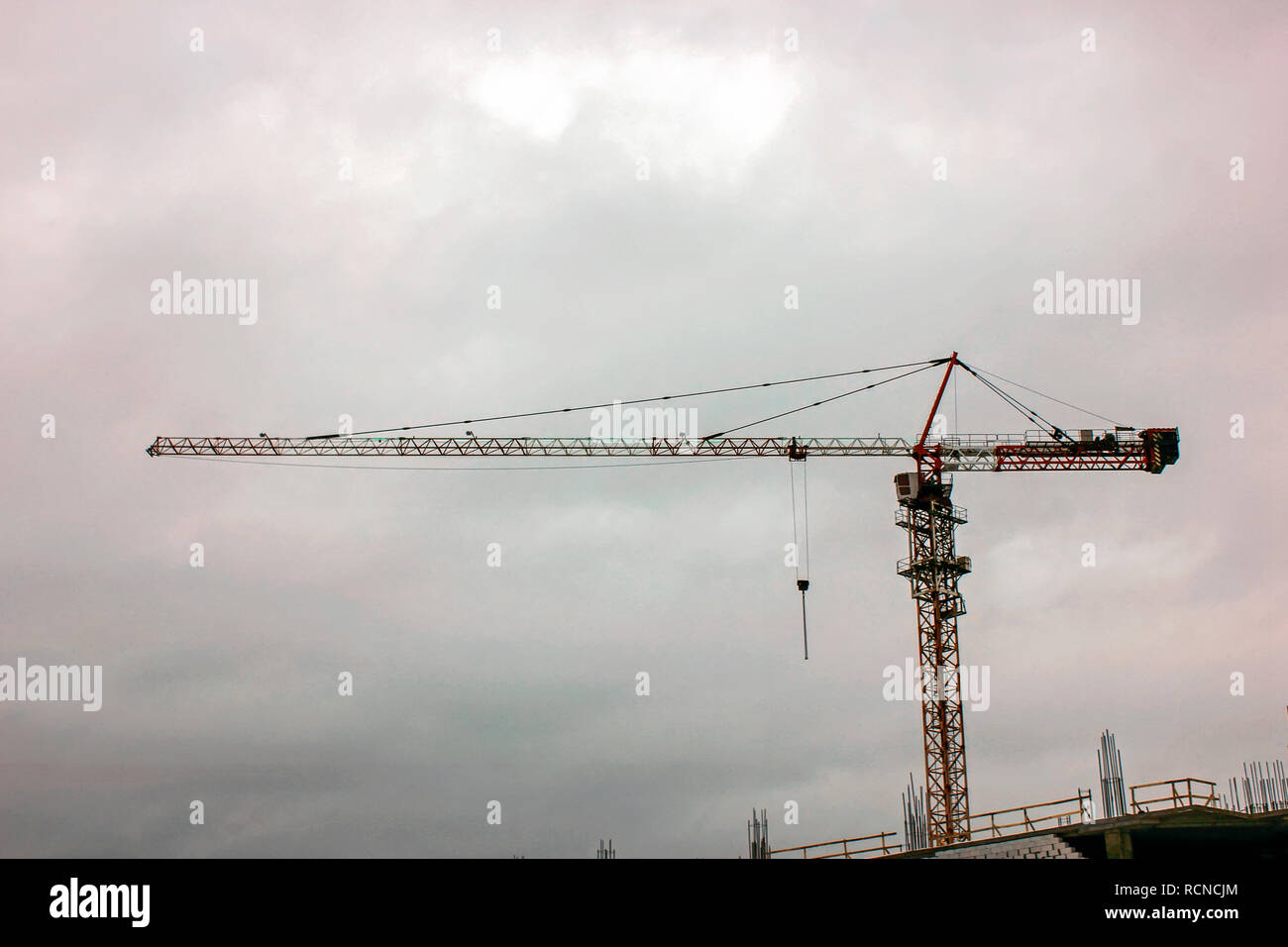 Construction crane bottom view in operation with cloud sky background ...