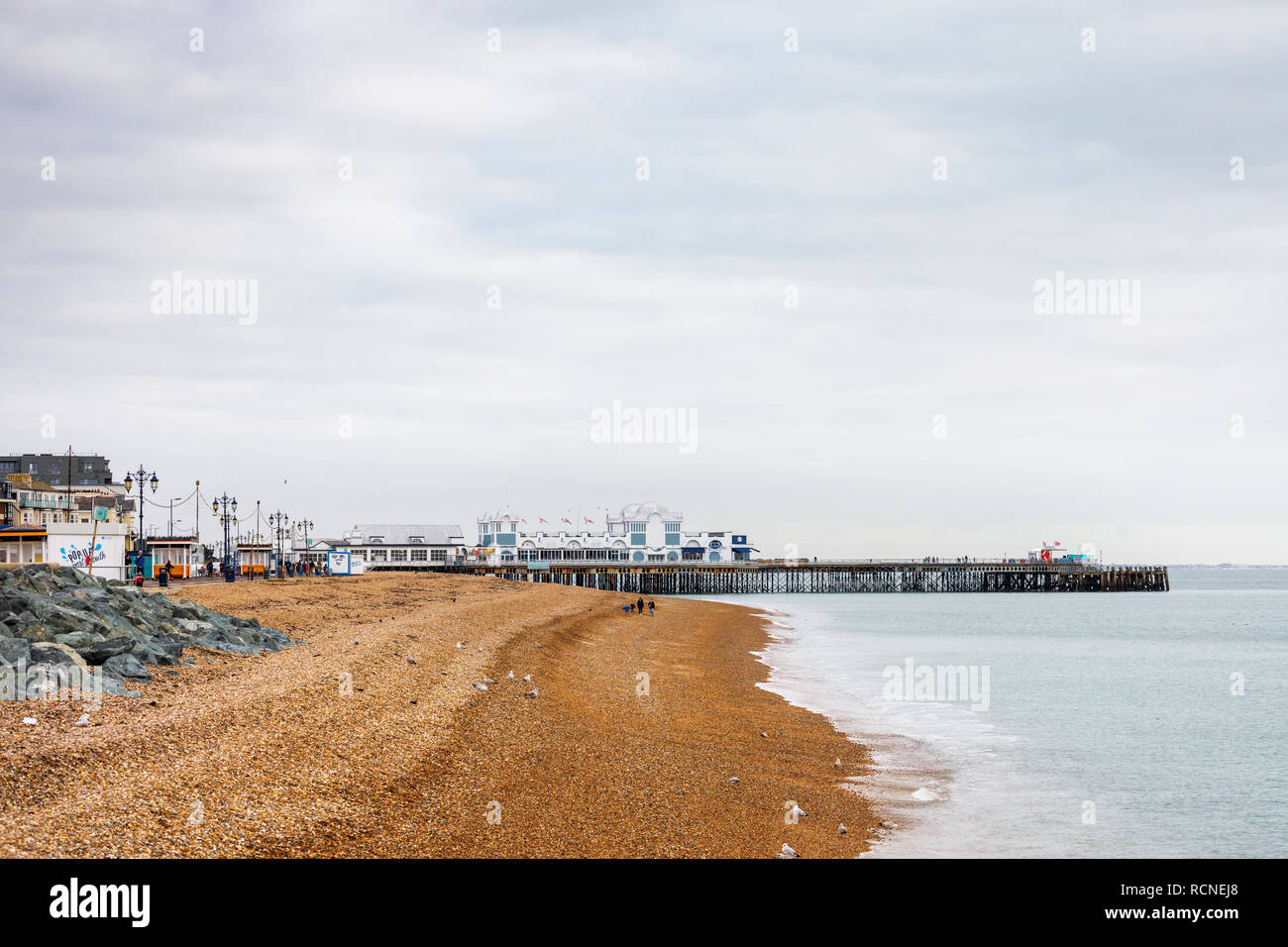 Seafront shoreline view of Victorian South Parade Pier and stony ...