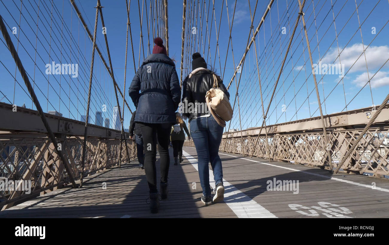 Two girls walk over the famous Brooklyn Bridge in New York Stock Photo ...