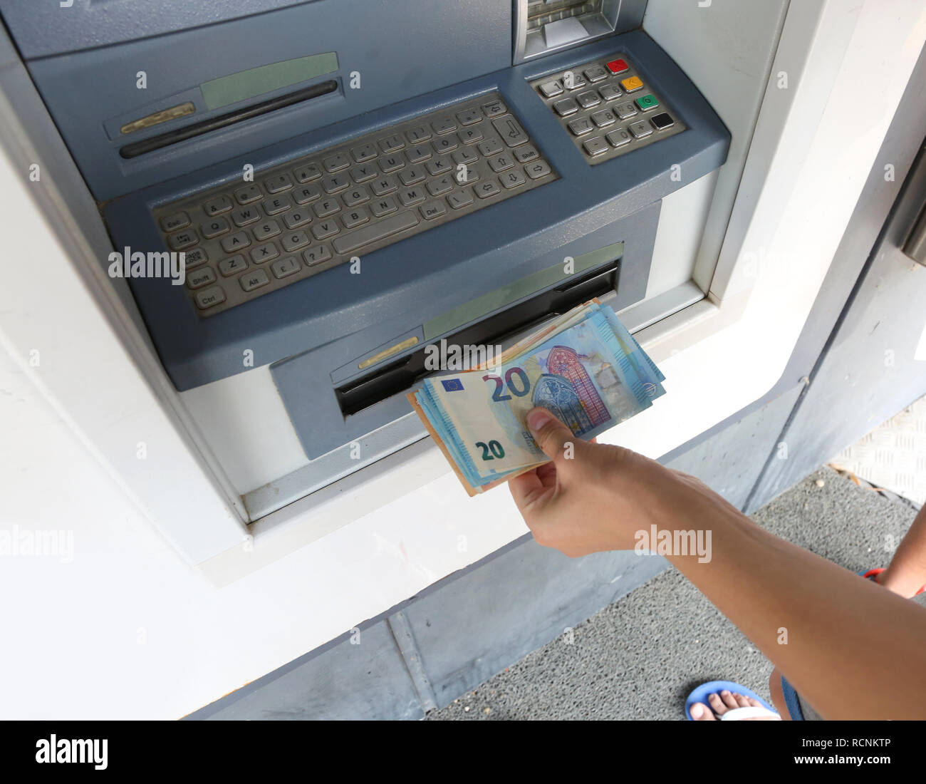ATM Machine and Euros Bankonotes with an hand in summer Stock Photo - Alamy
