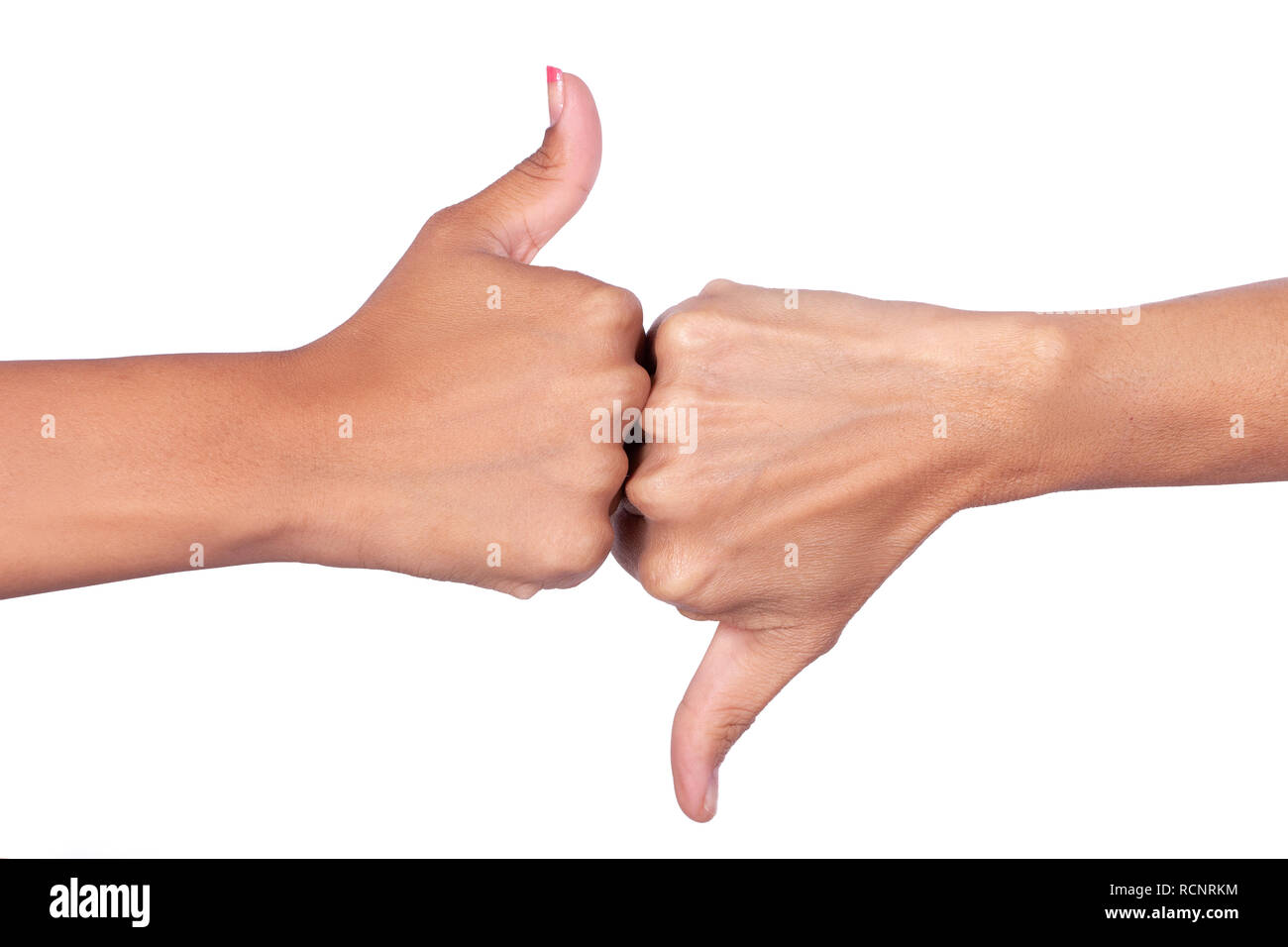 Female hands making signals with the thumb of one hand up and the other ...