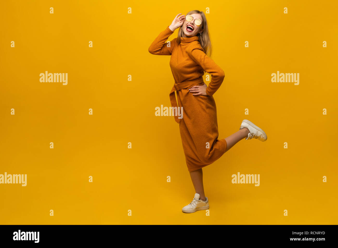 Full Length Portrait Of A Cheerful Beautiful Girl Wearing Dress Having