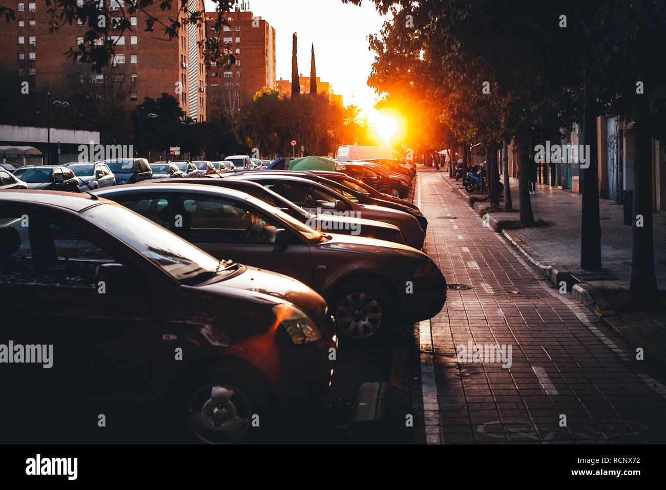 Valencia, Spain - January 13, 2019: A street at sunset full of parked ...
