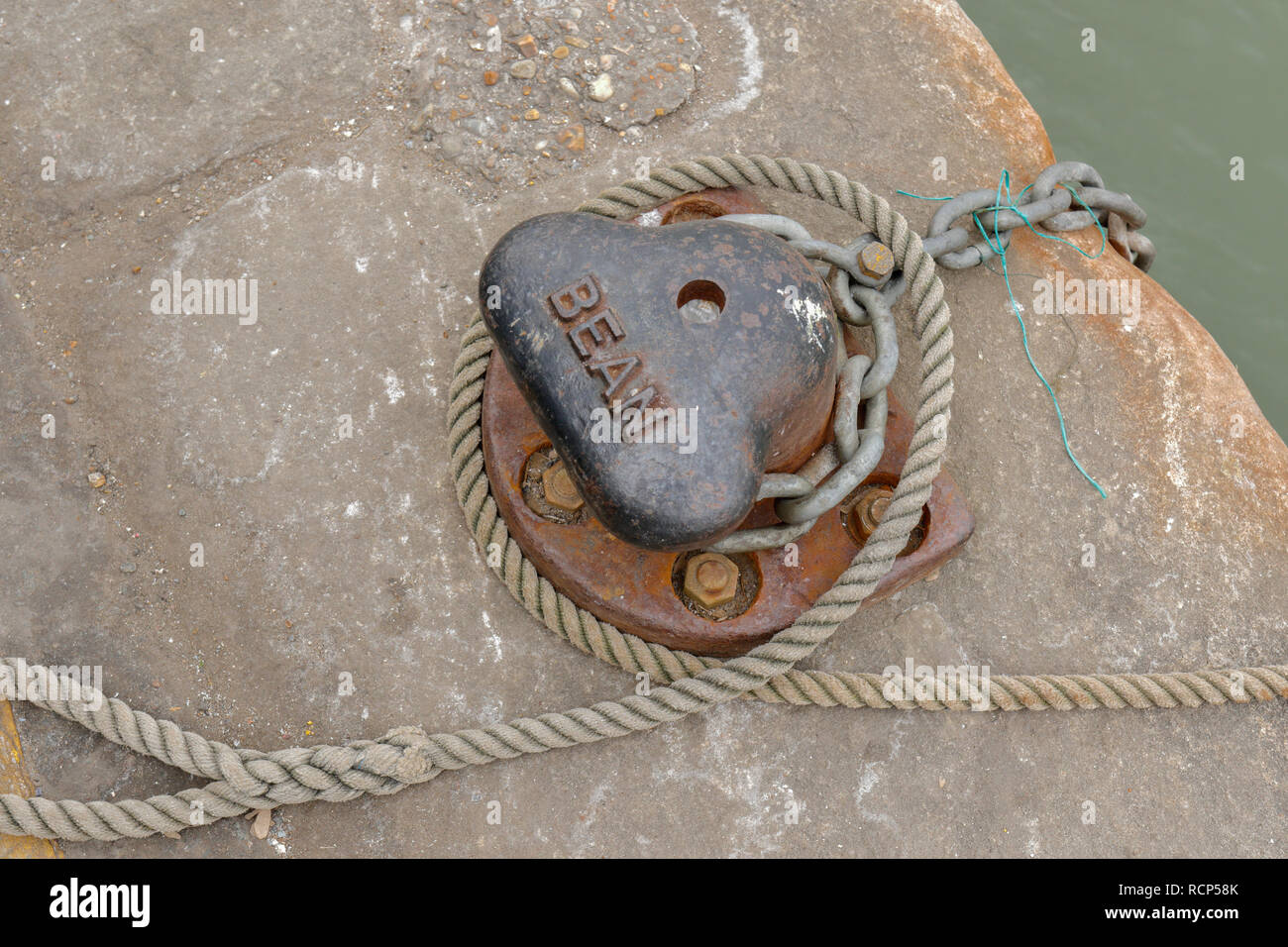 Quayside steel harbour capstan, ship rope and chains Stock Photo - Alamy