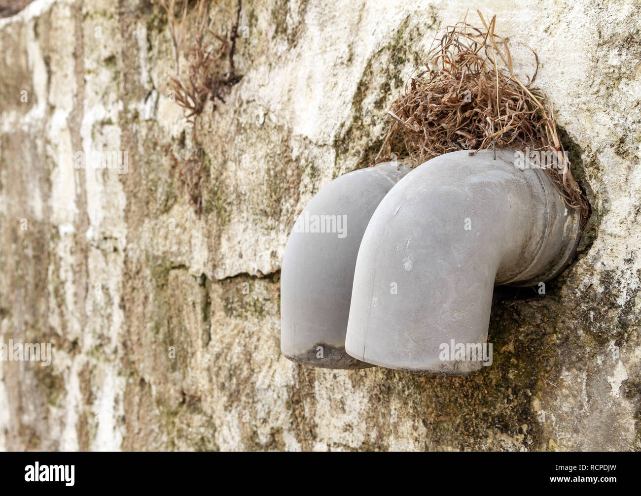 Two plastic drain pipes from the wall to the outside Stock Photo - Alamy