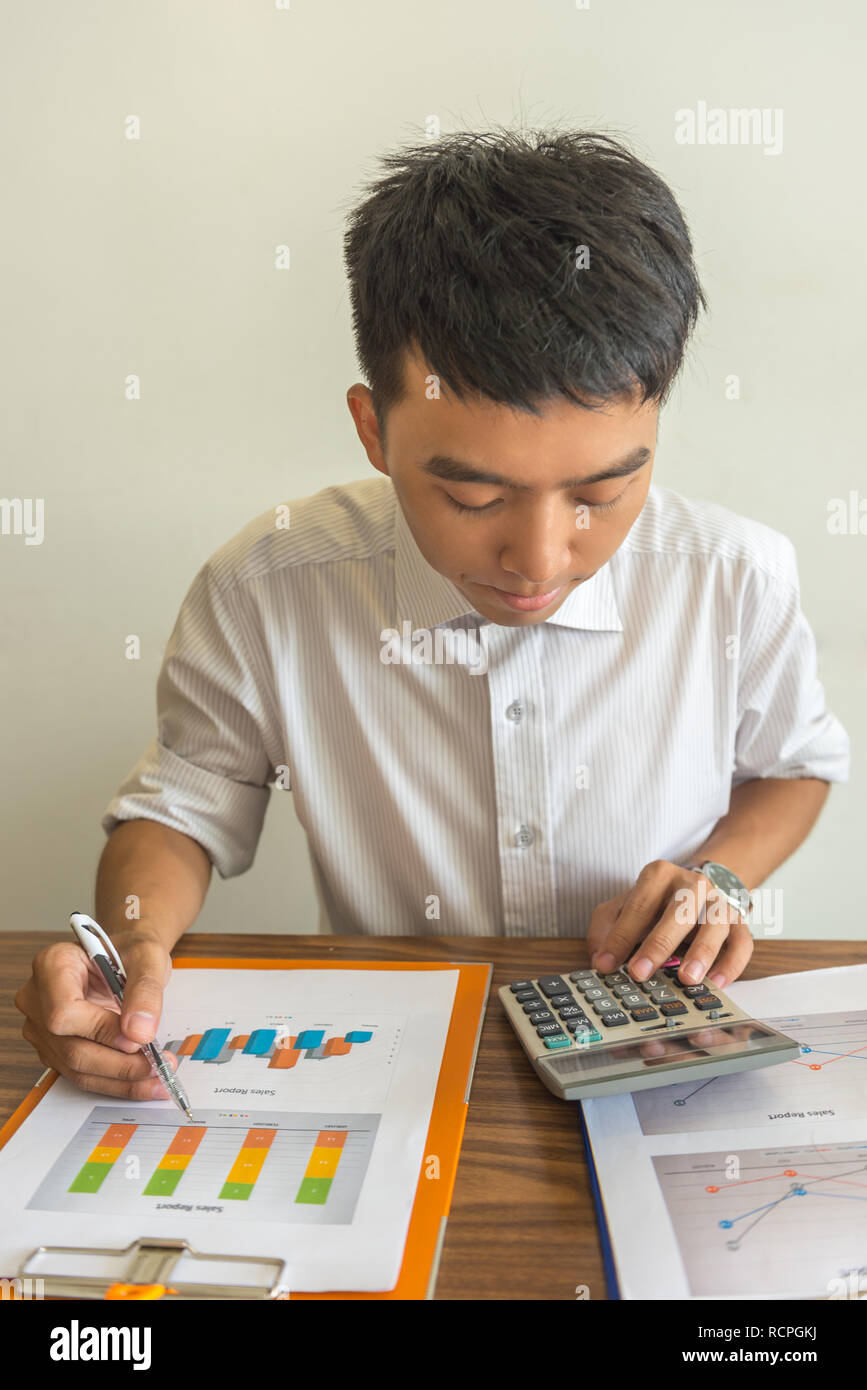 Business employee using calculator and reading financial report Stock ...