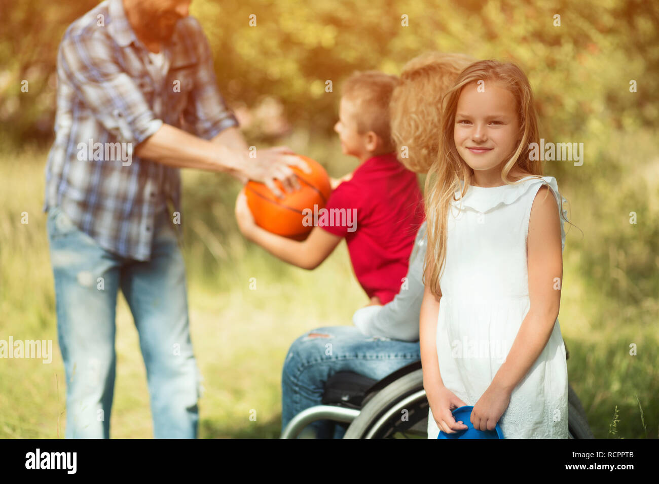Small daugher of a disabled woman is smiling at camera Stock Photo - Alamy