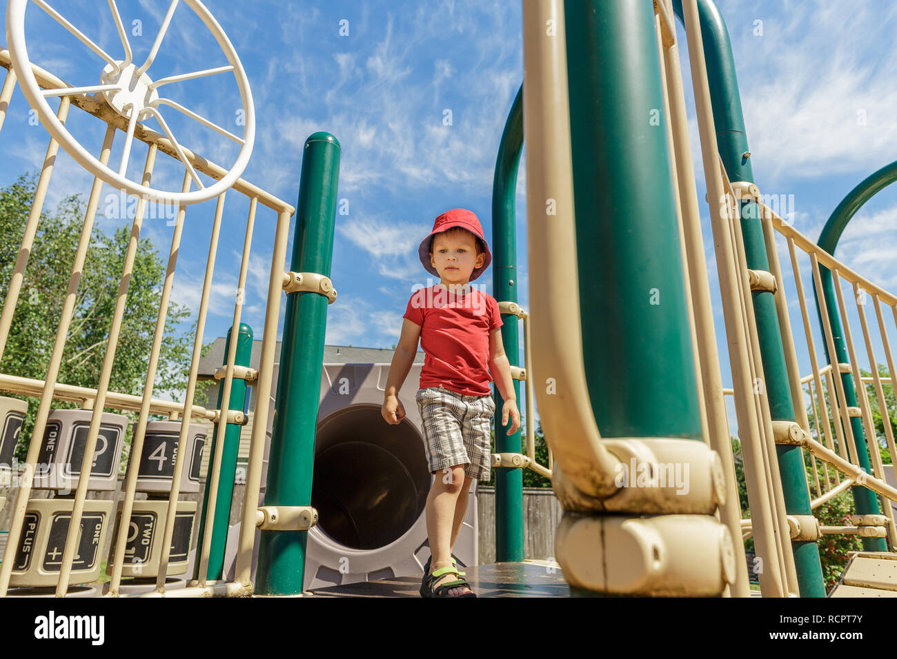 Three years old boy playing in the public playground in neighborhood in ...