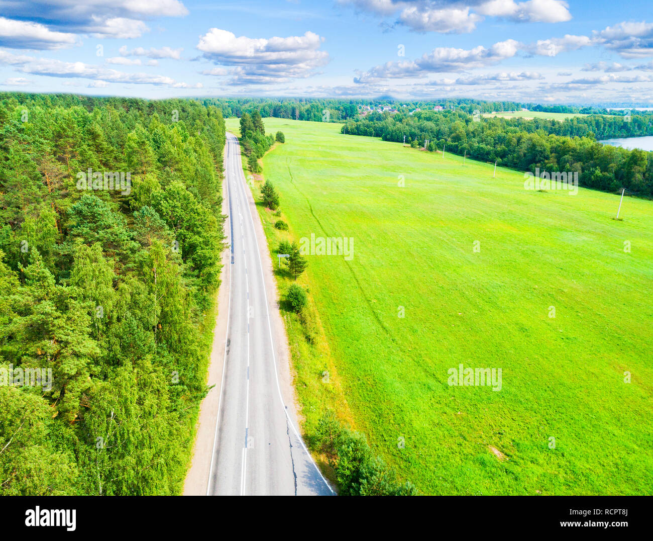 Aerial view of a country road in the forest with moving cars. Landscape ...