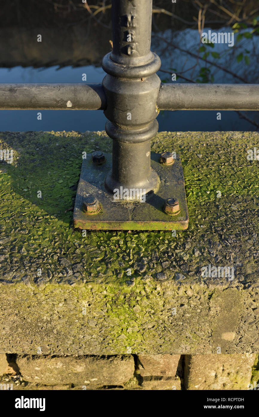 Metal post fixed to concrete wall with four steel bolts, and metal rail ...