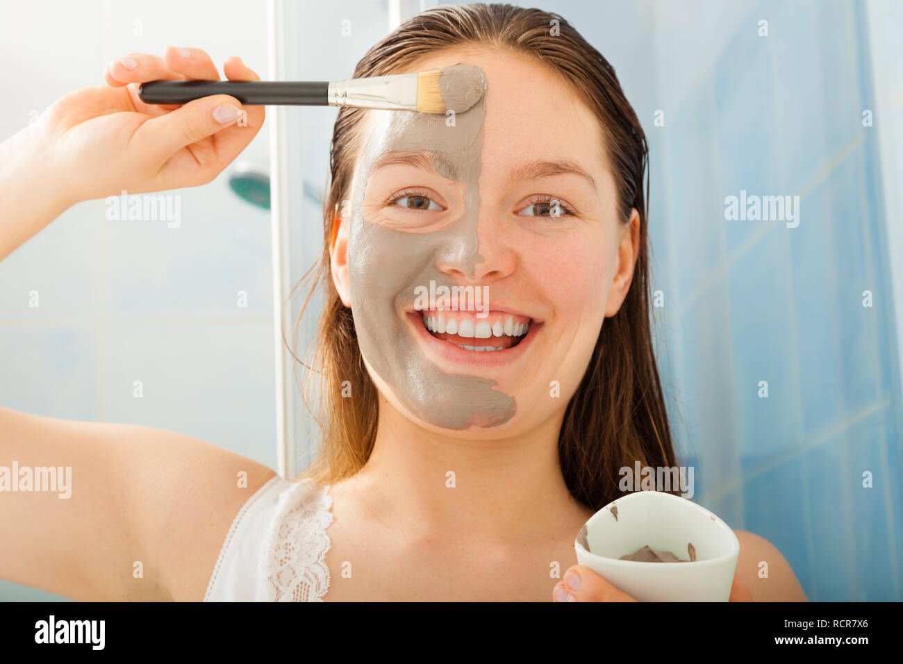 Beauty procedures skin care concept. Young woman applying facial gray ...