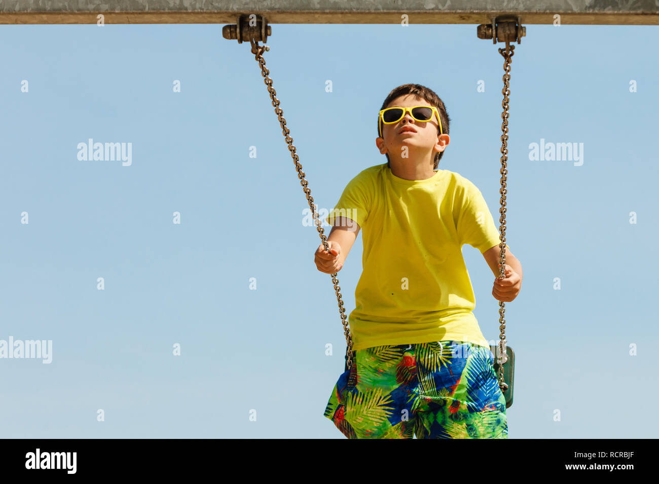 Rest and relax for children. Little boy in sunglasses resting swinging ...