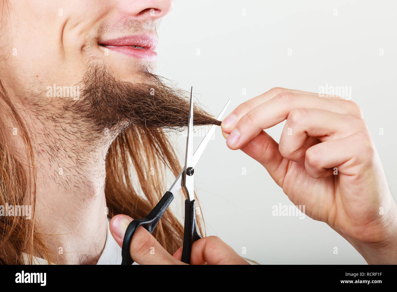 Cut and shave concept. Young man with long beard holding scissors. Part ...