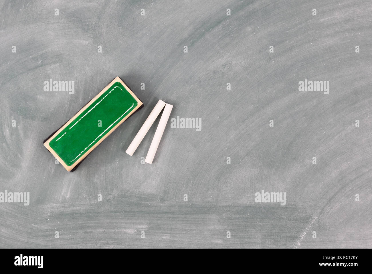 Back to school concept with green erased chalkboard and eraser plus ...