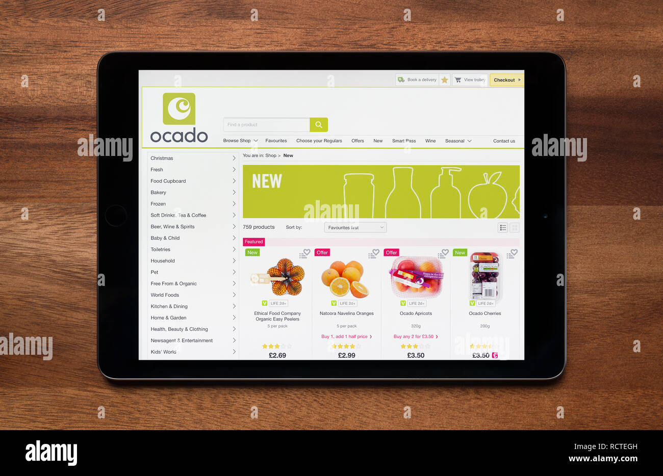 The website of Ocado is seen on an iPad tablet, which is resting on a wooden table (Editorial ...