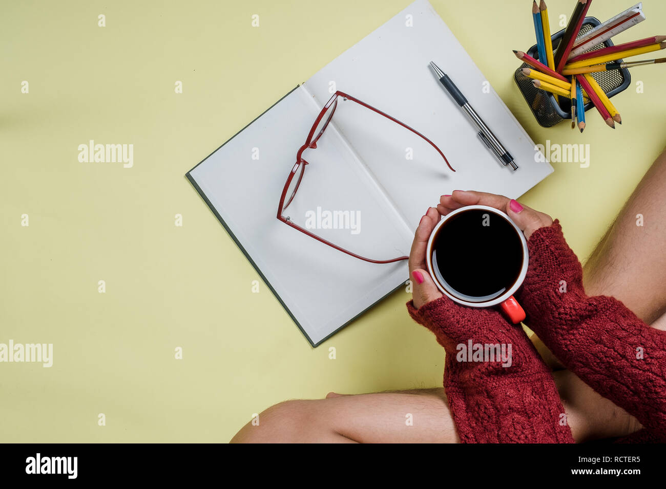 Woman hands holding cup of coffee on yellow desk with book and pen, Top ...