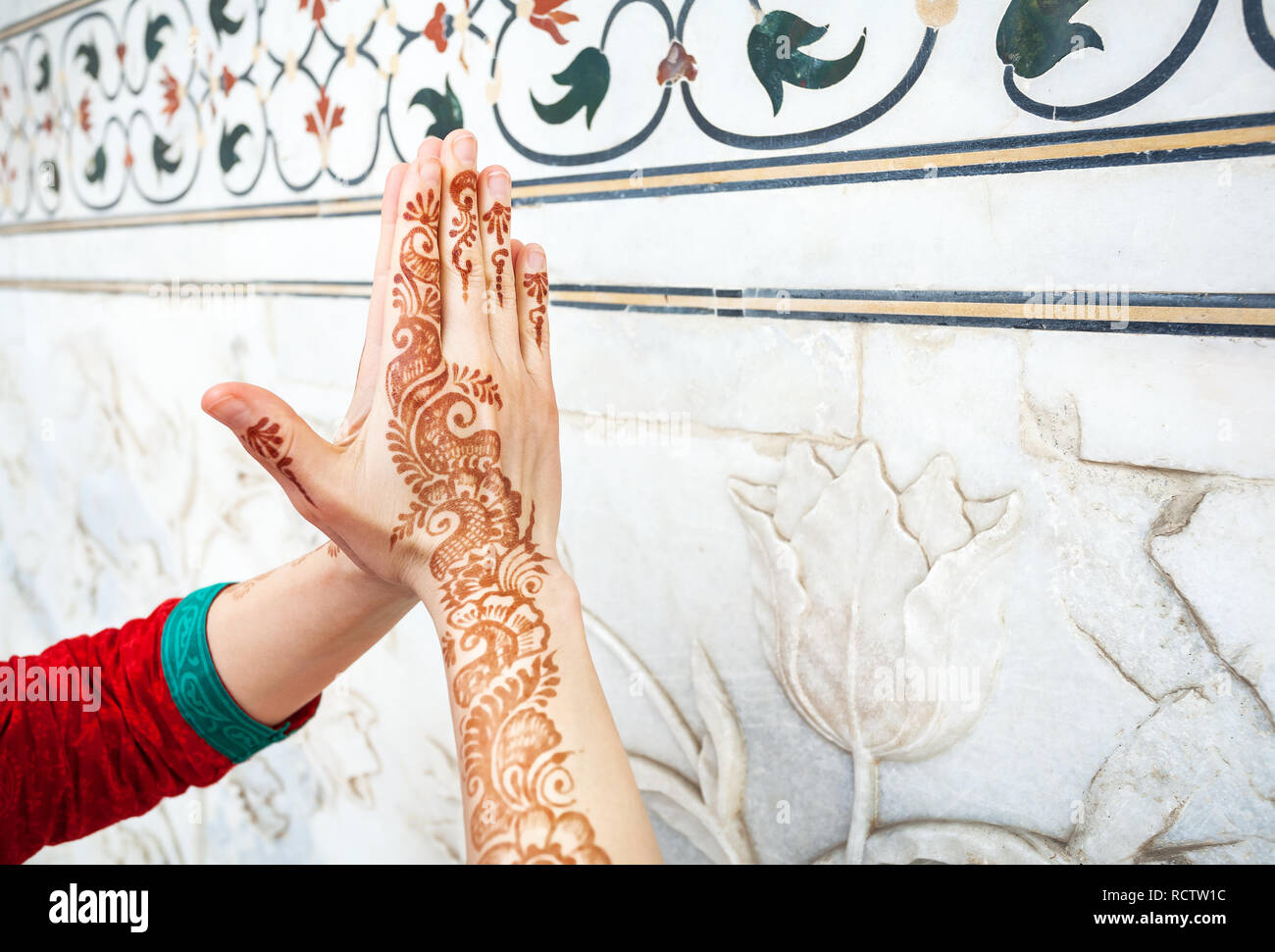 Woman in red Indian costume ding Namaste gesture by hand in henna ...