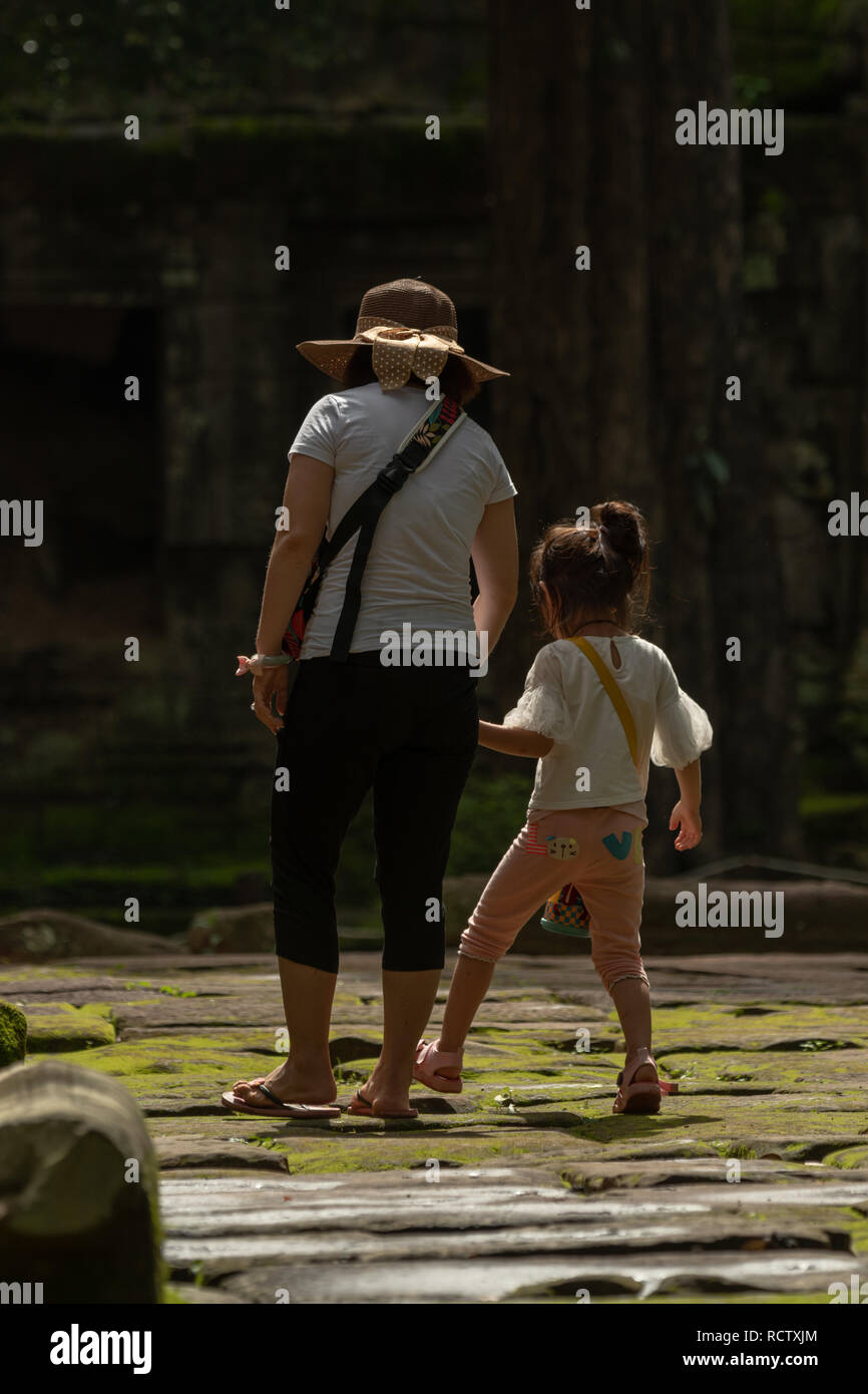 Girl jumps over mossy flagstones with mother Stock Photo - Alamy