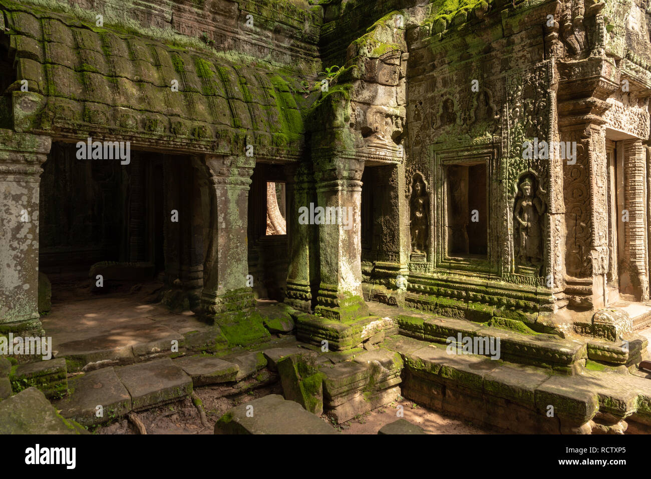 Moss-covered columns and statues by temple doorway Stock Photo - Alamy
