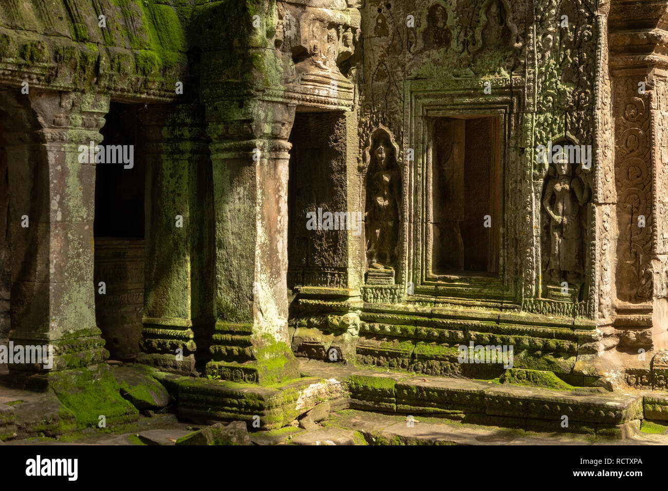 Moss-covered columns and statues in temple wall Stock Photo - Alamy