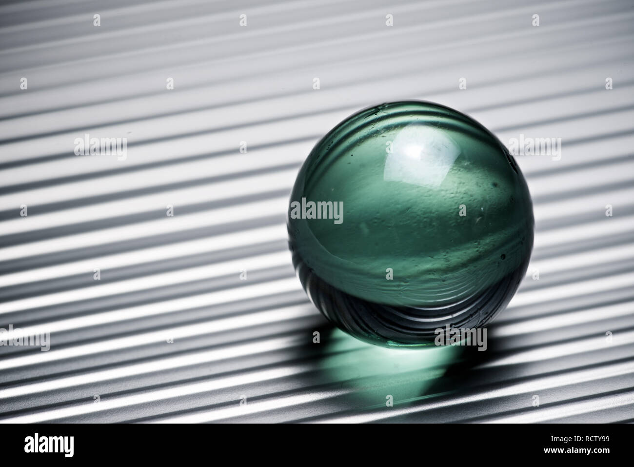 Glass ball on a metallic table Stock Photo - Alamy