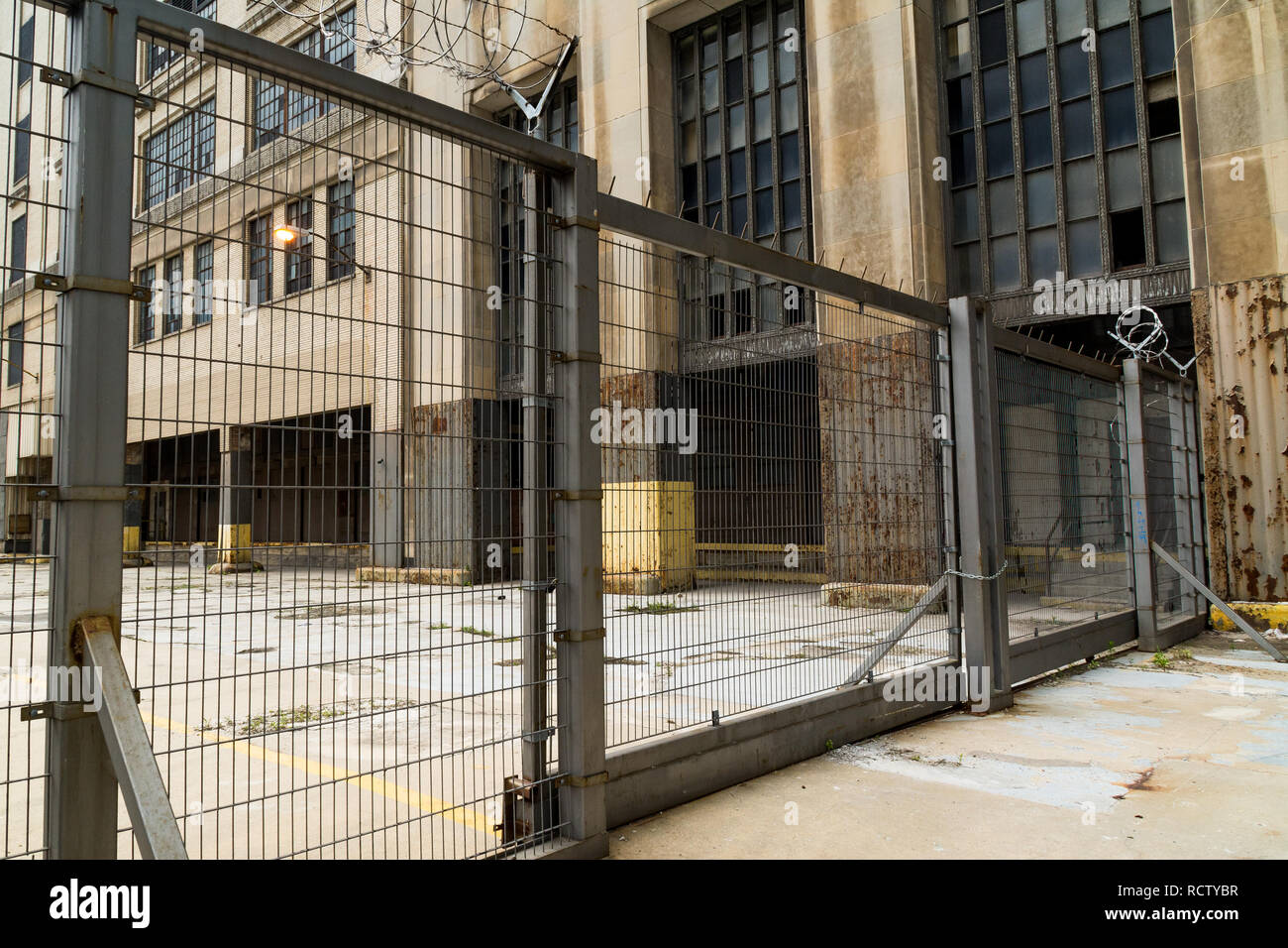 Industrial metal gate with abandoned building in background. Chicago ...
