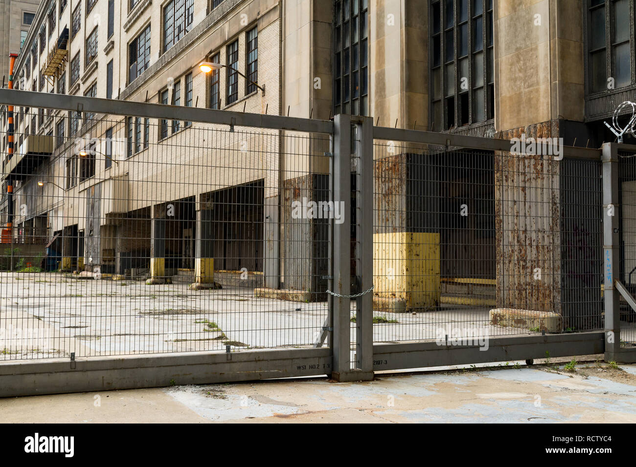 Industrial metal gate with abandoned building in background. Chicago ...