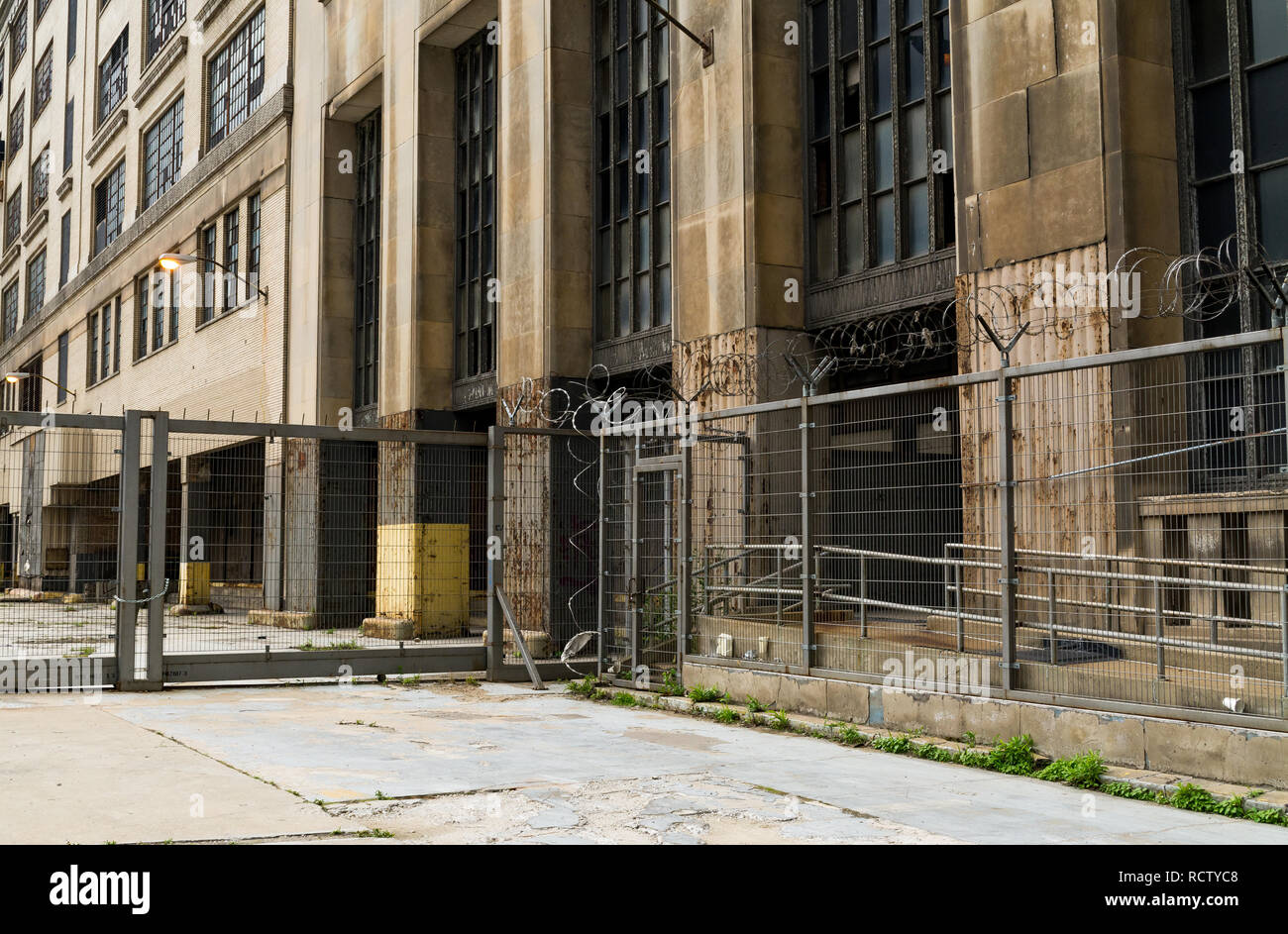Industrial metal gate with abandoned building in background. Chicago ...