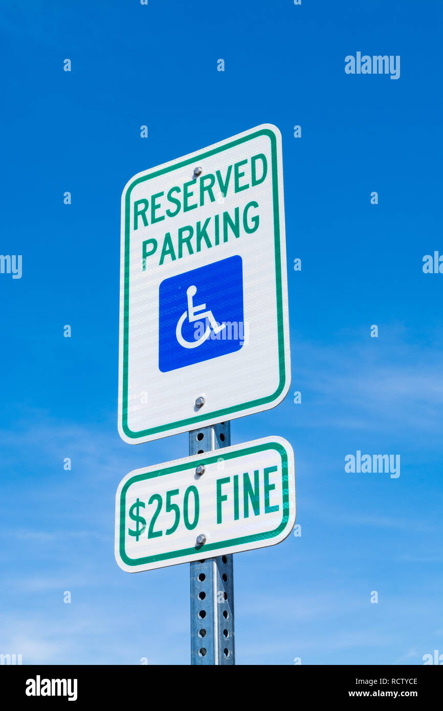 The "Reserved Parking for Disabled" sign with blue skies in the ...