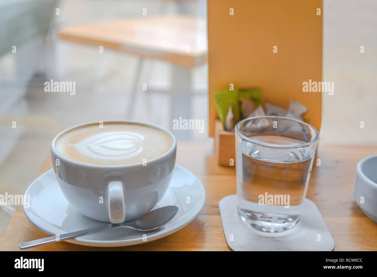 Big white cup of cafe latte with heart latte art on table in cafeteria ...