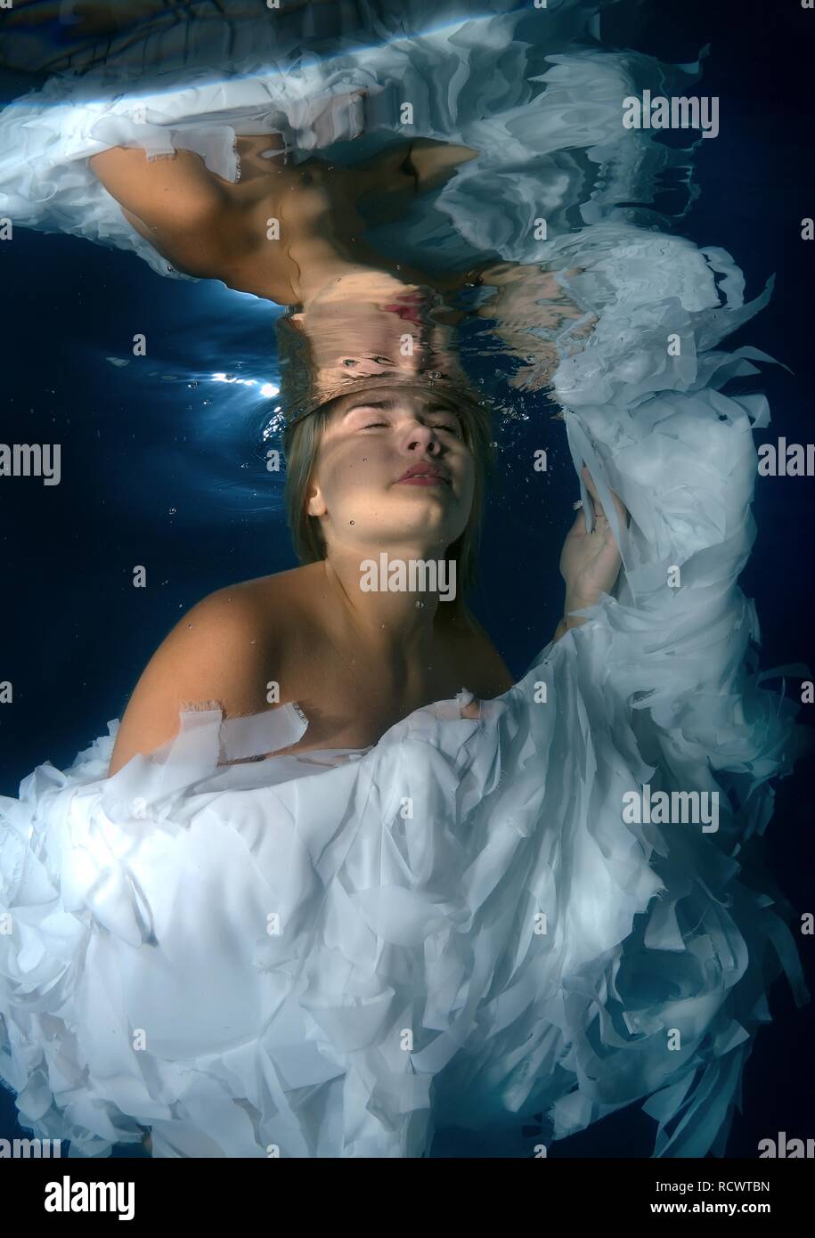 Woman presenting underwater fashion in a pool Stock Photo - Alamy