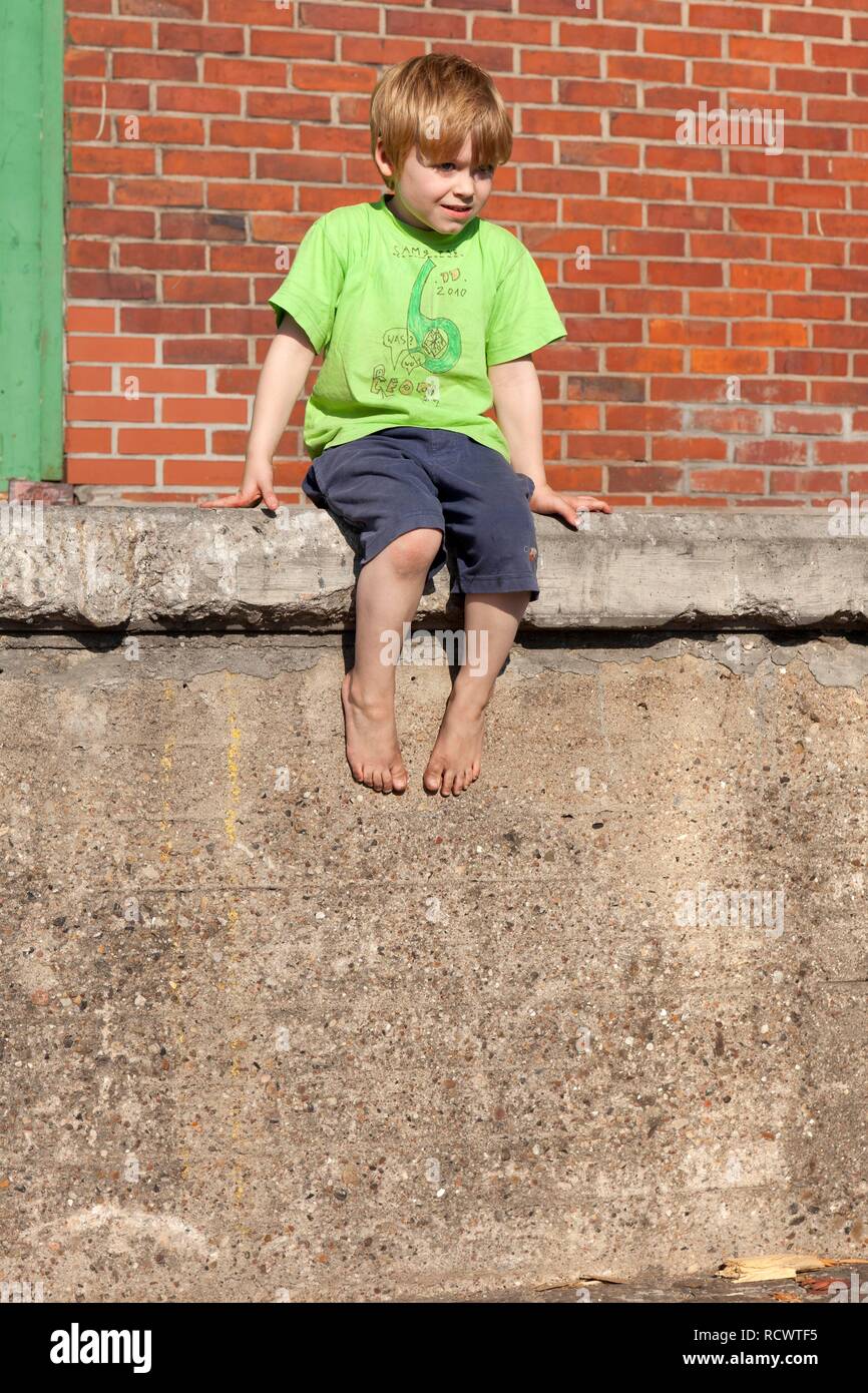 Boy Sitting Against Wall