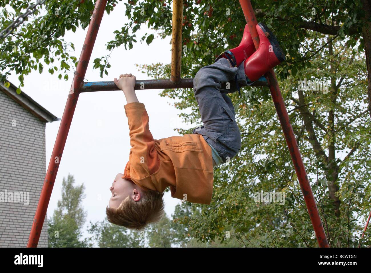 Little boy playing on monkey bars Stock Photo - Alamy