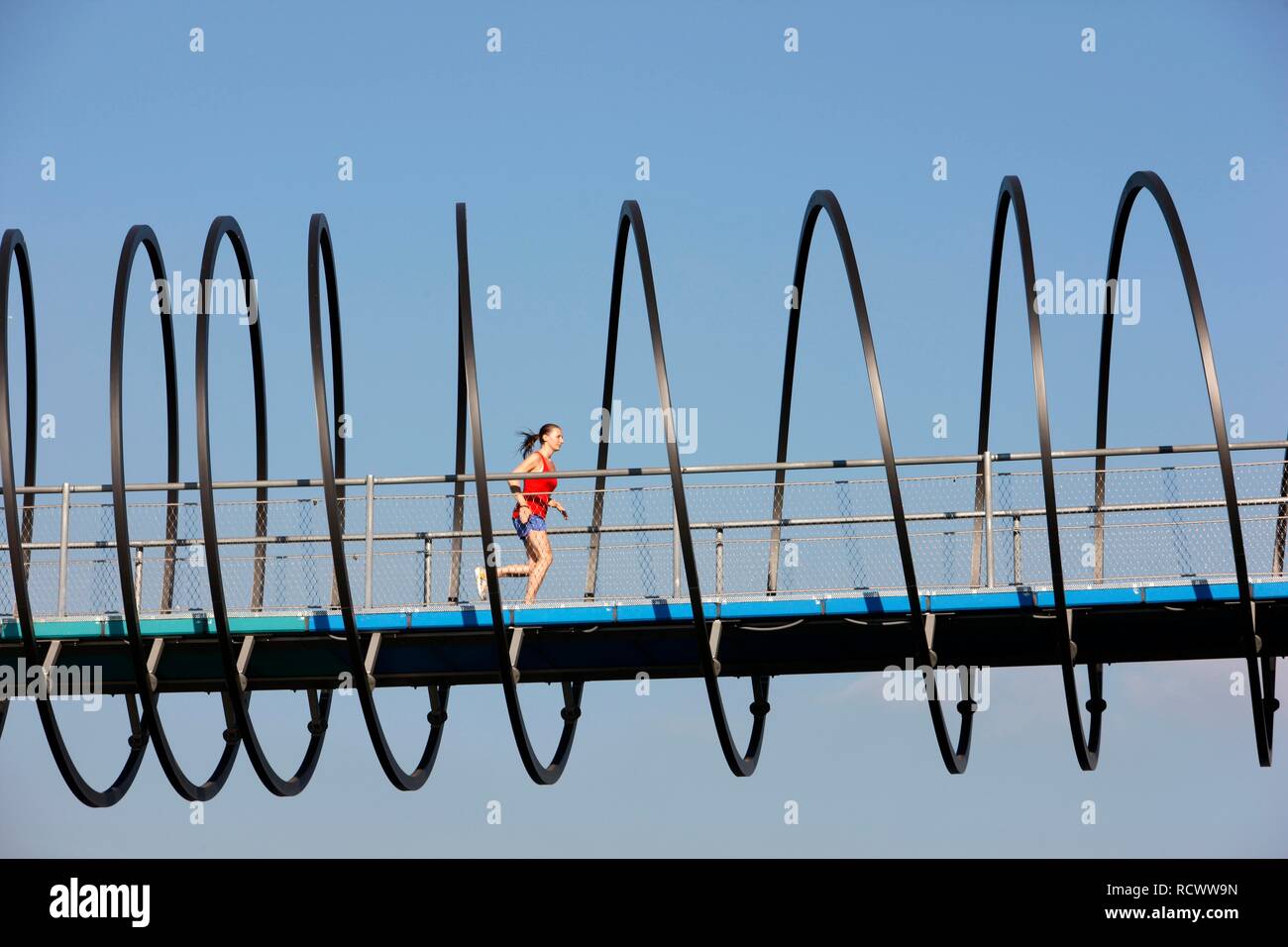 Jogger, runner, woman running on a pedestrian bridge, Slinky Springs to ...
