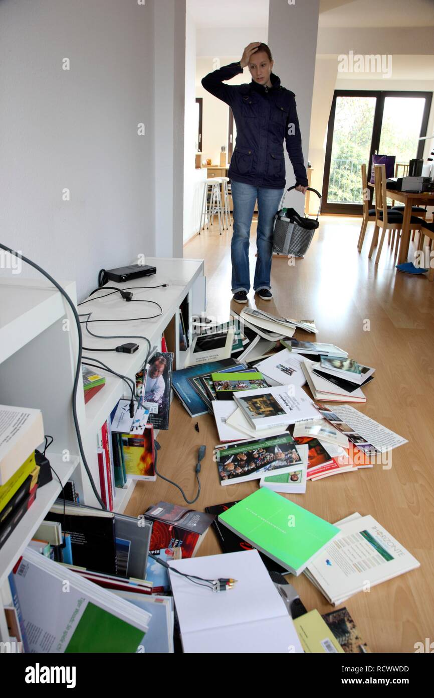 Young woman discovering the scene of a burglary, ransacked shelf Stock ...