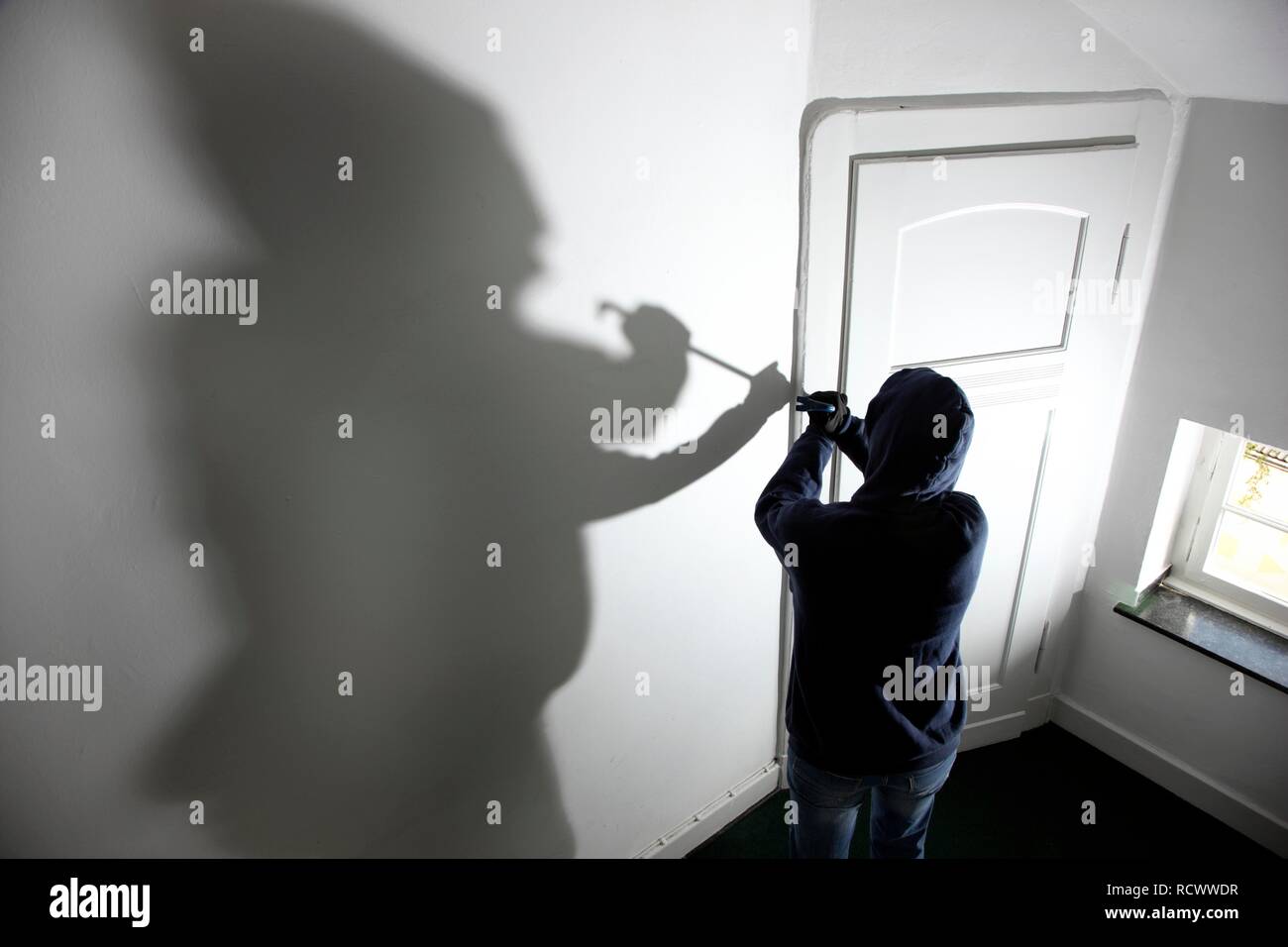 Burglary, burglar on a staircase of an apartment house during the day ...