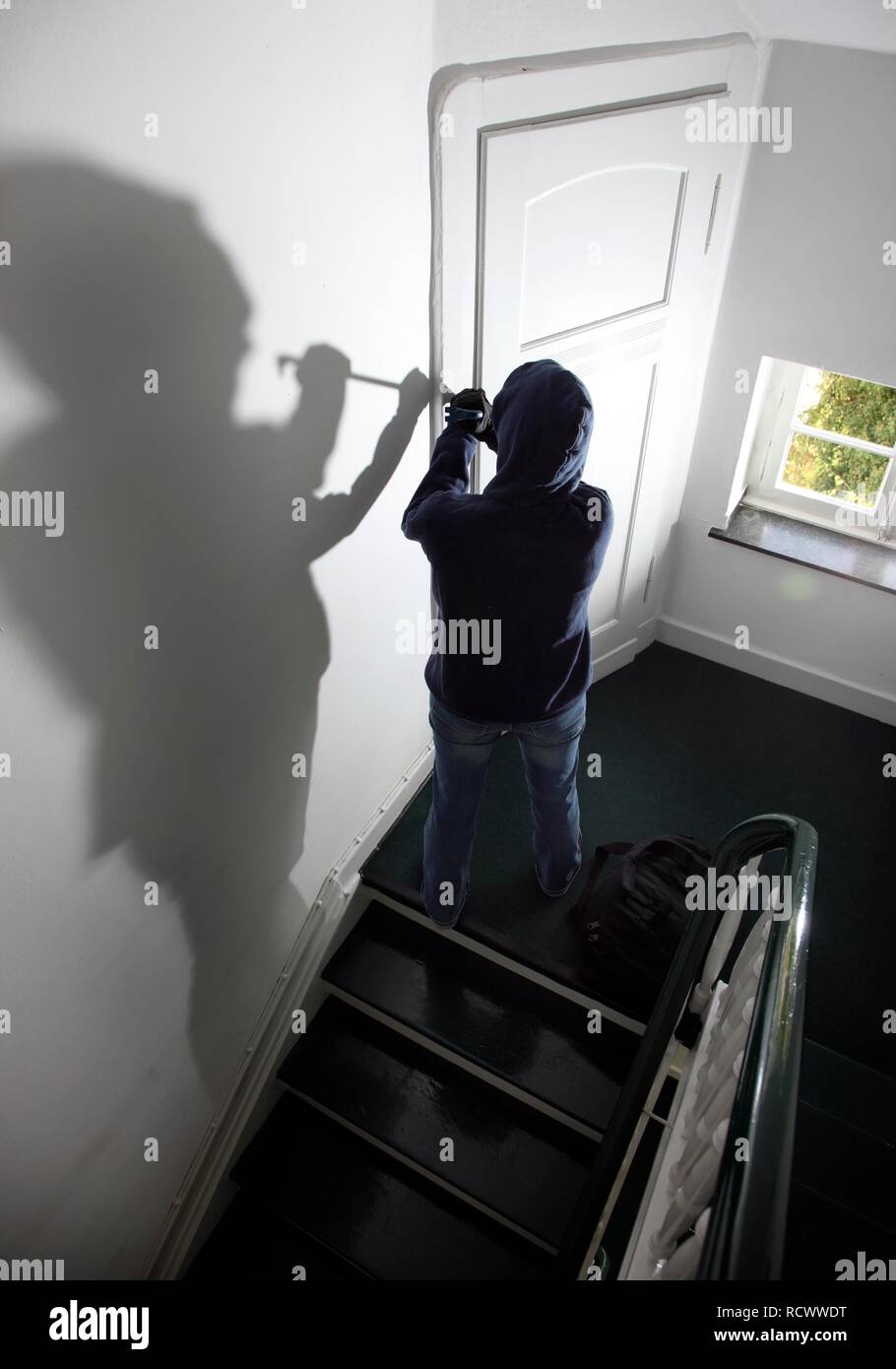 Burglary, burglar on a staircase of an apartment house during the day ...