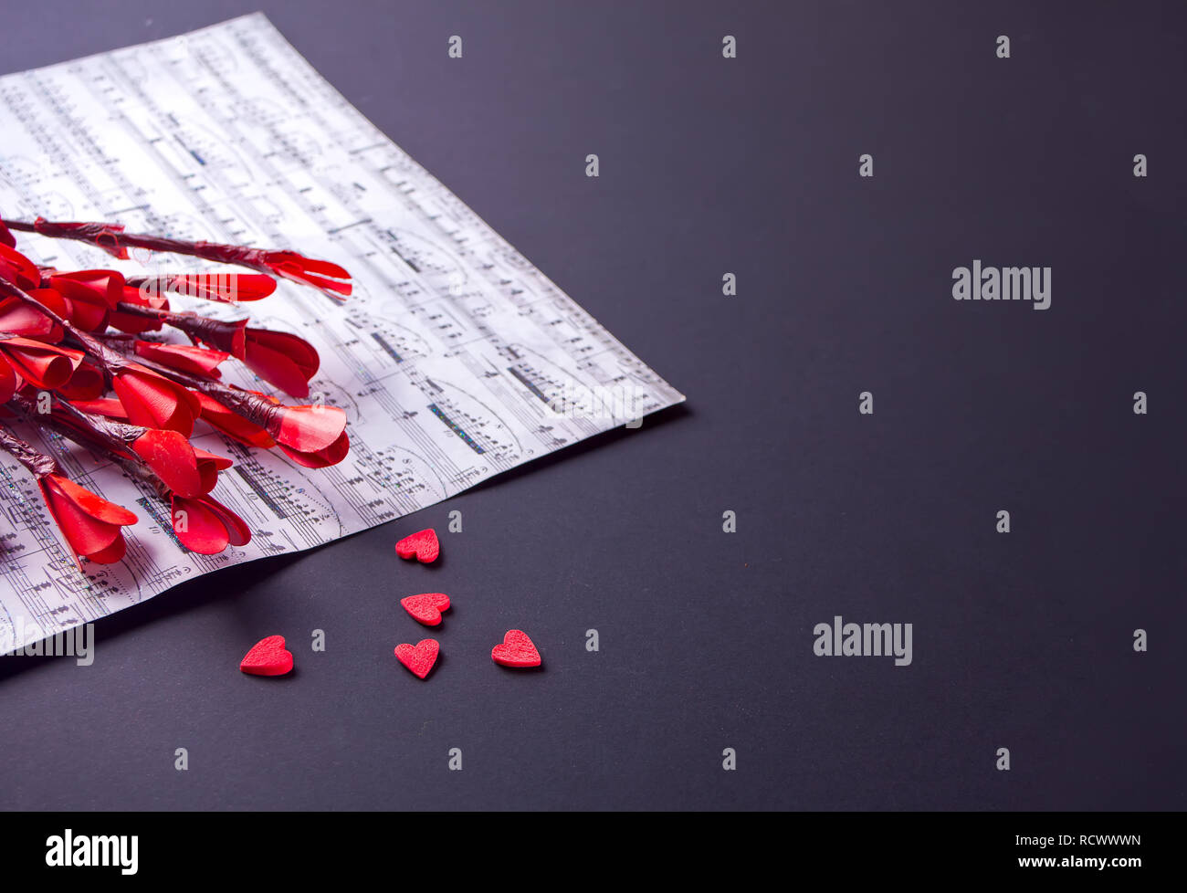 Valentines day concept with paper flowers, candy sweet hearts and music ...
