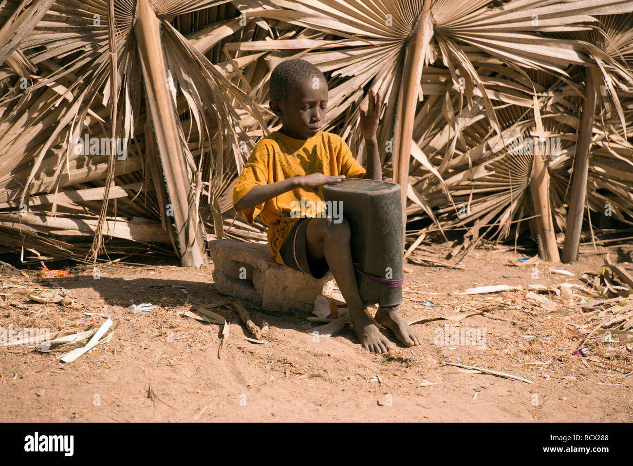 A young indigenous Jola tribe boy plays a drum during a traditional ...