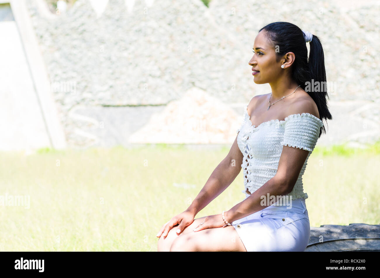 Front view of a single teen sitting and thinking looking at side ...