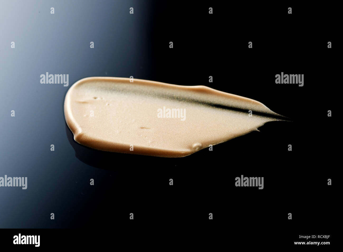 the texture of a foundation liquid. Black background Stock Photo - Alamy