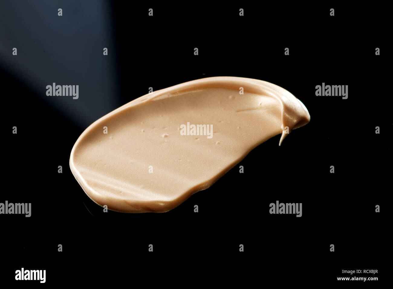the texture of a foundation liquid. Black background Stock Photo - Alamy