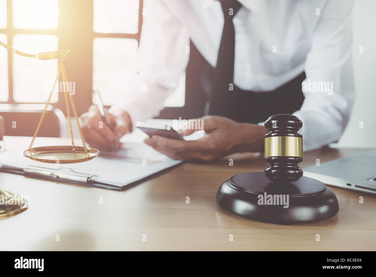 Male judge working with smart phone and sign contact and gavel on ...