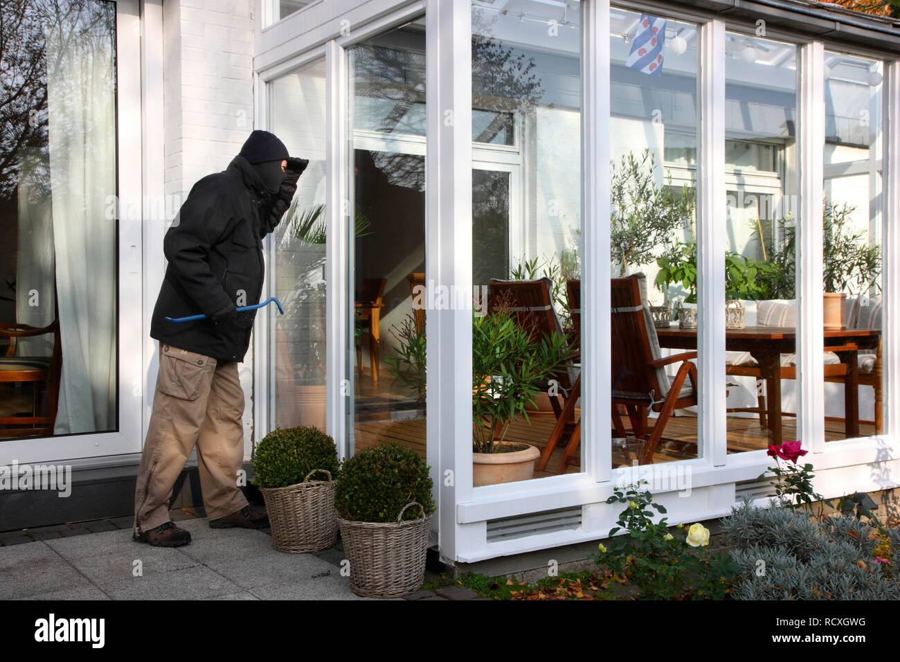 Burglar planning burglary, spying out a house, symbolic image for ...
