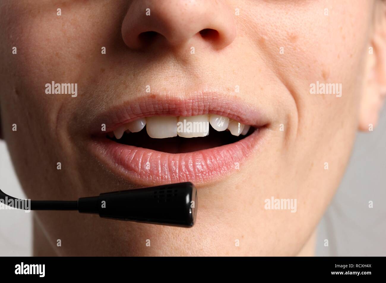 Young woman speaking into a headset Stock Photo - Alamy